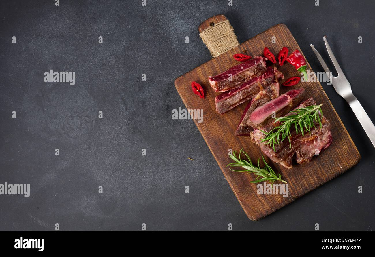 roasted piece of beef ribeye cut into pieces on a vintage brown ...