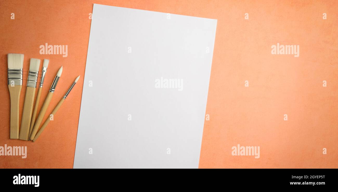 A clean white sheet and brushes on a textured background with space to ...