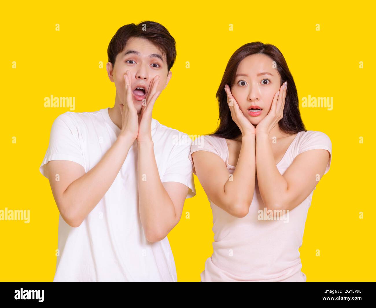 Young couple being amazed.Isolated on yellow background Stock Photo - Alamy