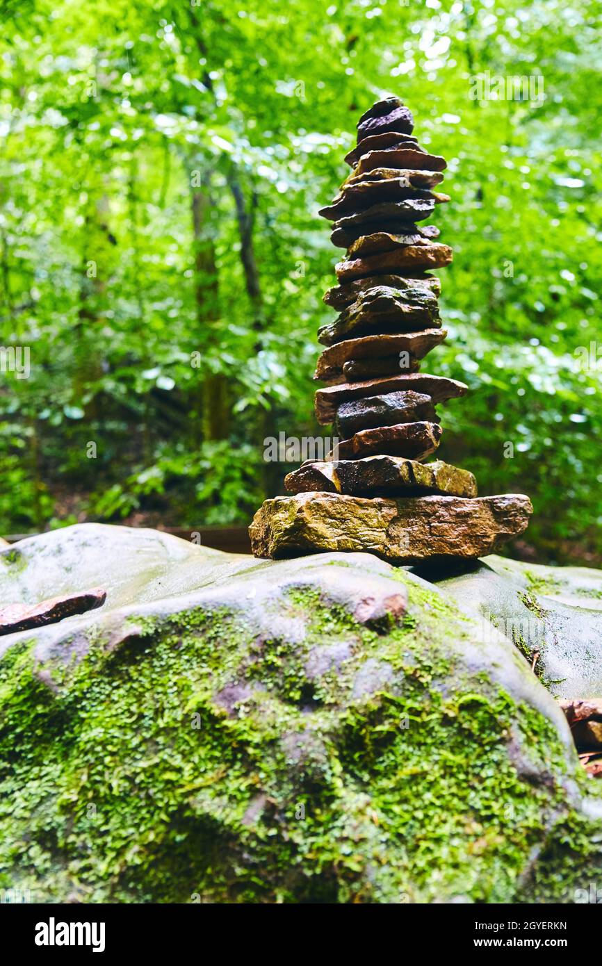 View of tall cairn stack of stones in woods on mossy boulder Stock ...