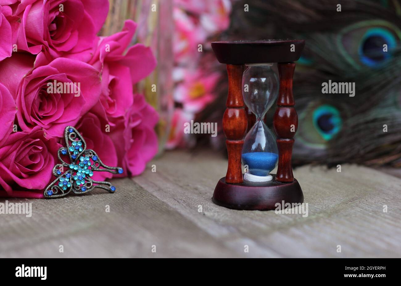 Vintage Hourglass With Pink Roses and Peacock Feathers Stock Photo - Alamy