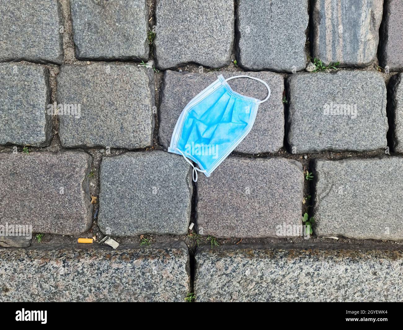 Close-up image of a surgical mask dropped and abandoned in the street ...