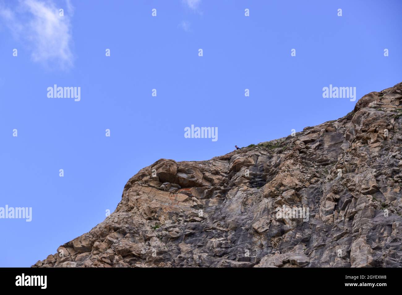 Low angle view of steep cliff in the blue sky background Stock Photo ...