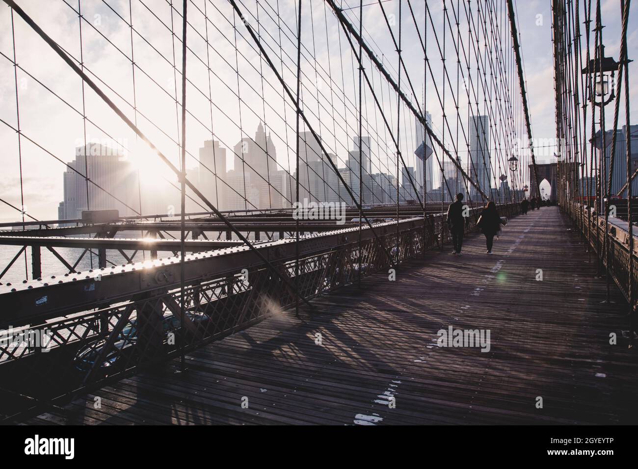 Couple walking on pedestrian path across Brooklyn bridge. New York City ...