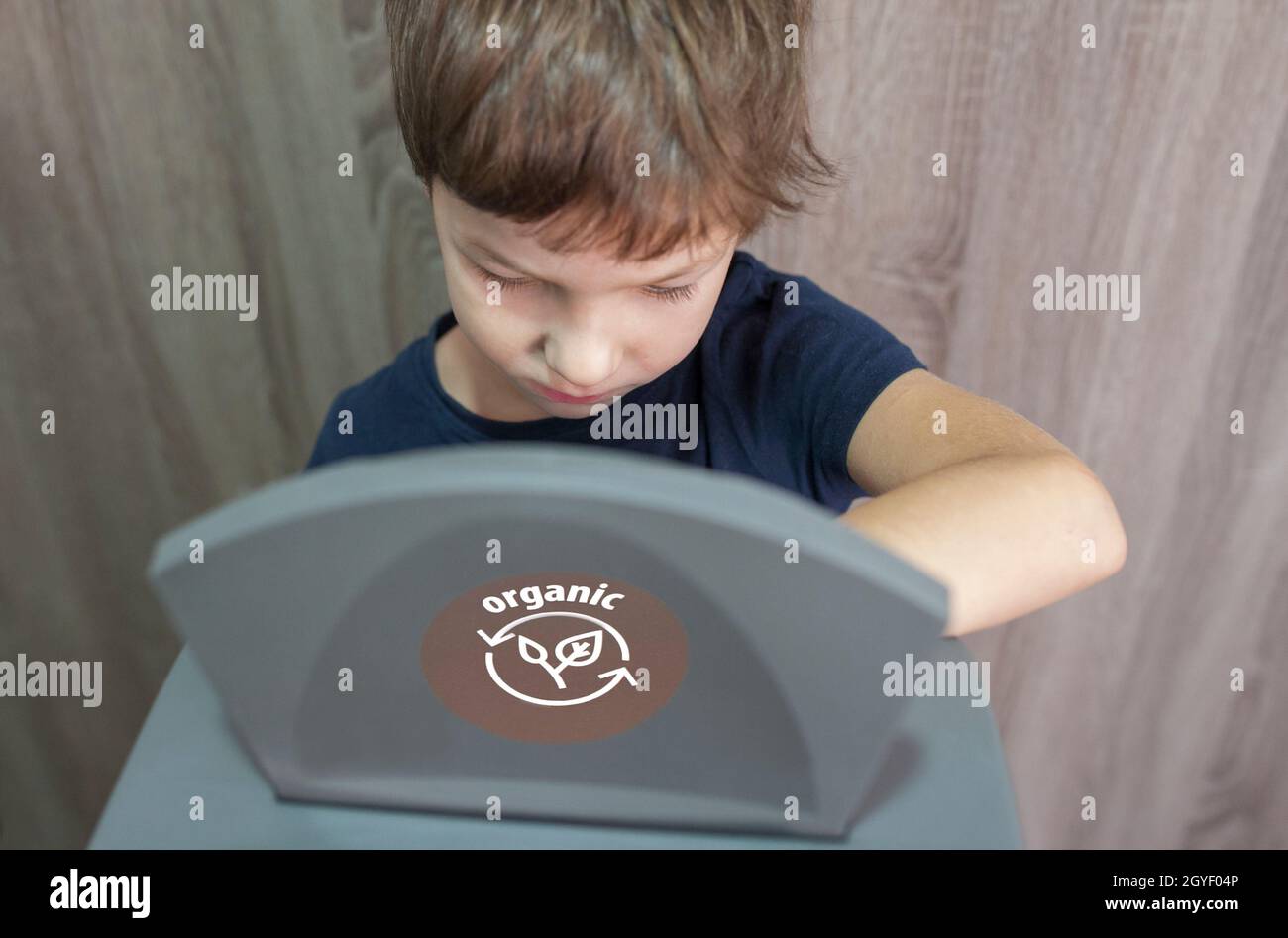 Child boy throwing prganic item to waste bin for orgnic at home ...