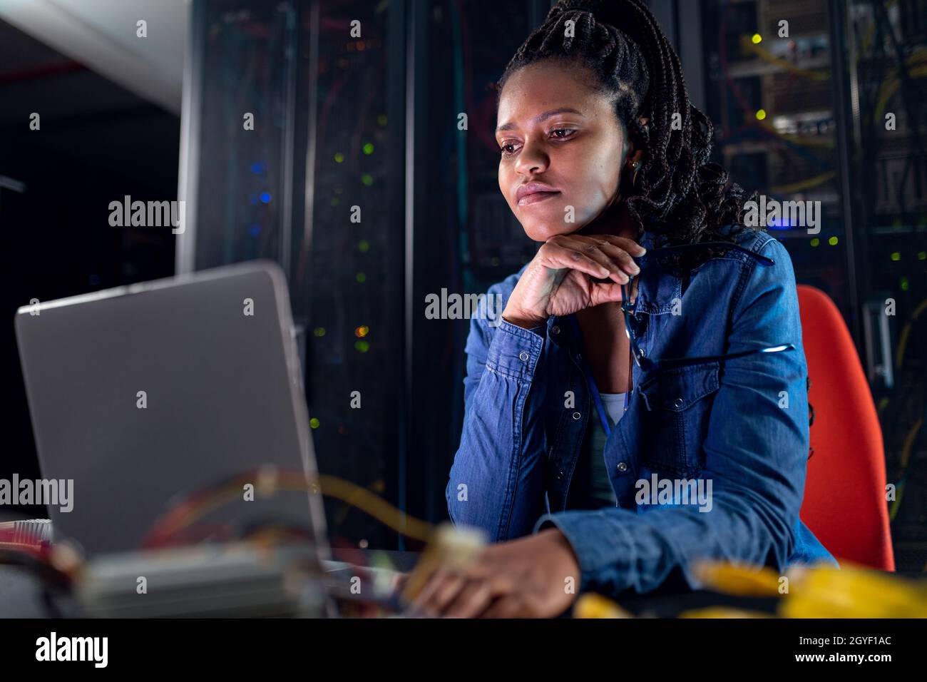 African american female computer technician using laptop working in ...