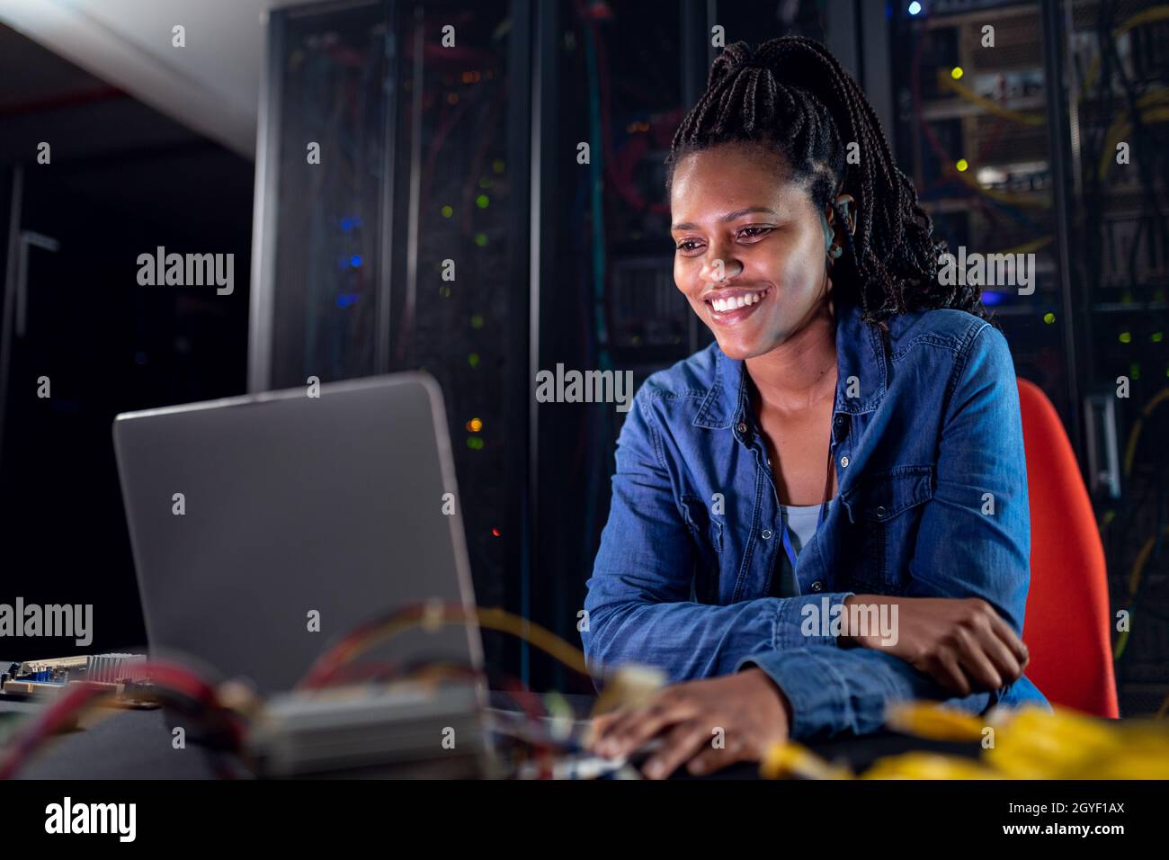 African american female computer technician using laptop working in ...