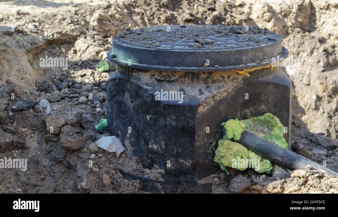 Installation, assembly of a new plastic sewer hatch into the ground ...