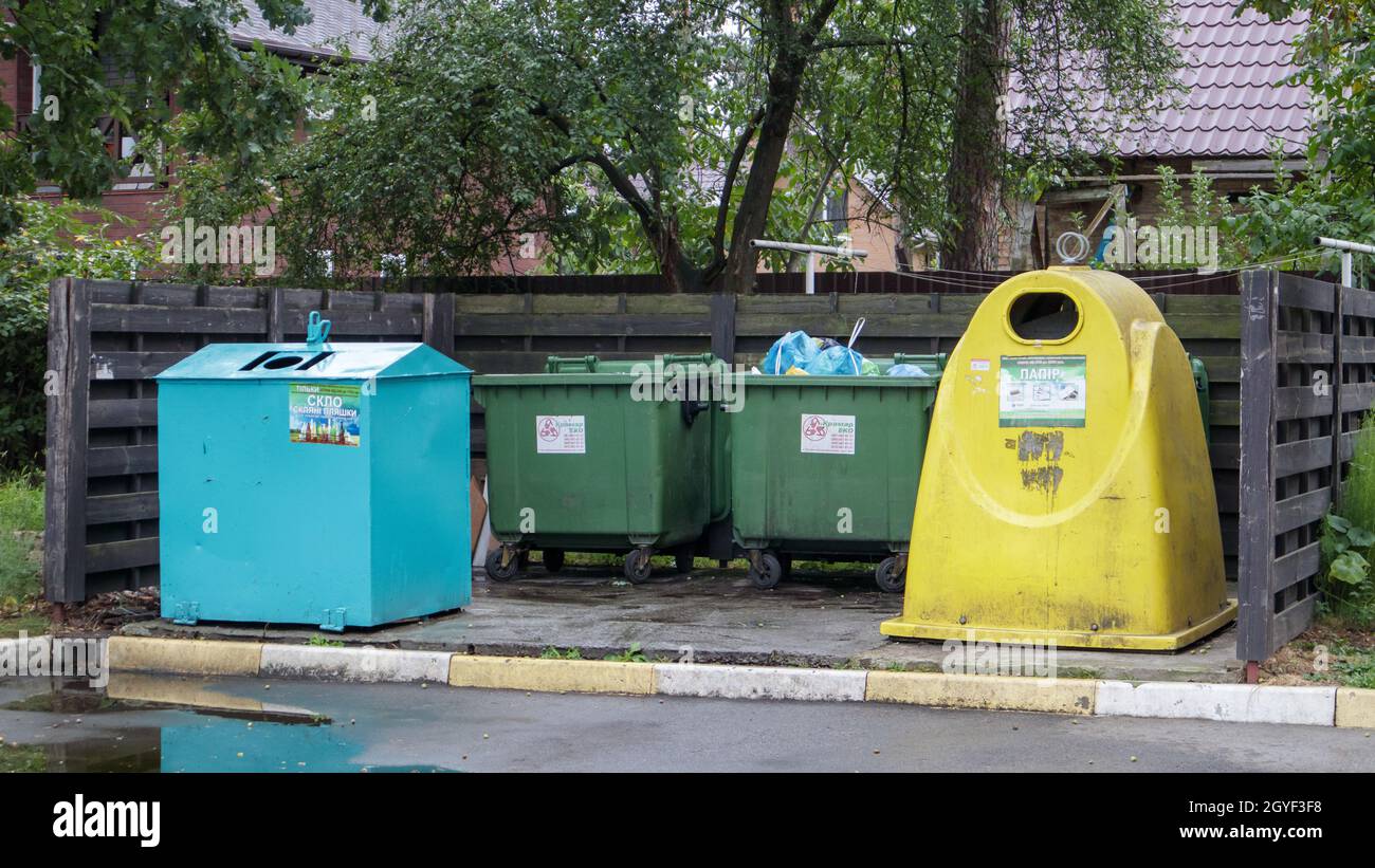 Four plastic and metal garbage bins for sorting waste in the courtyard ...