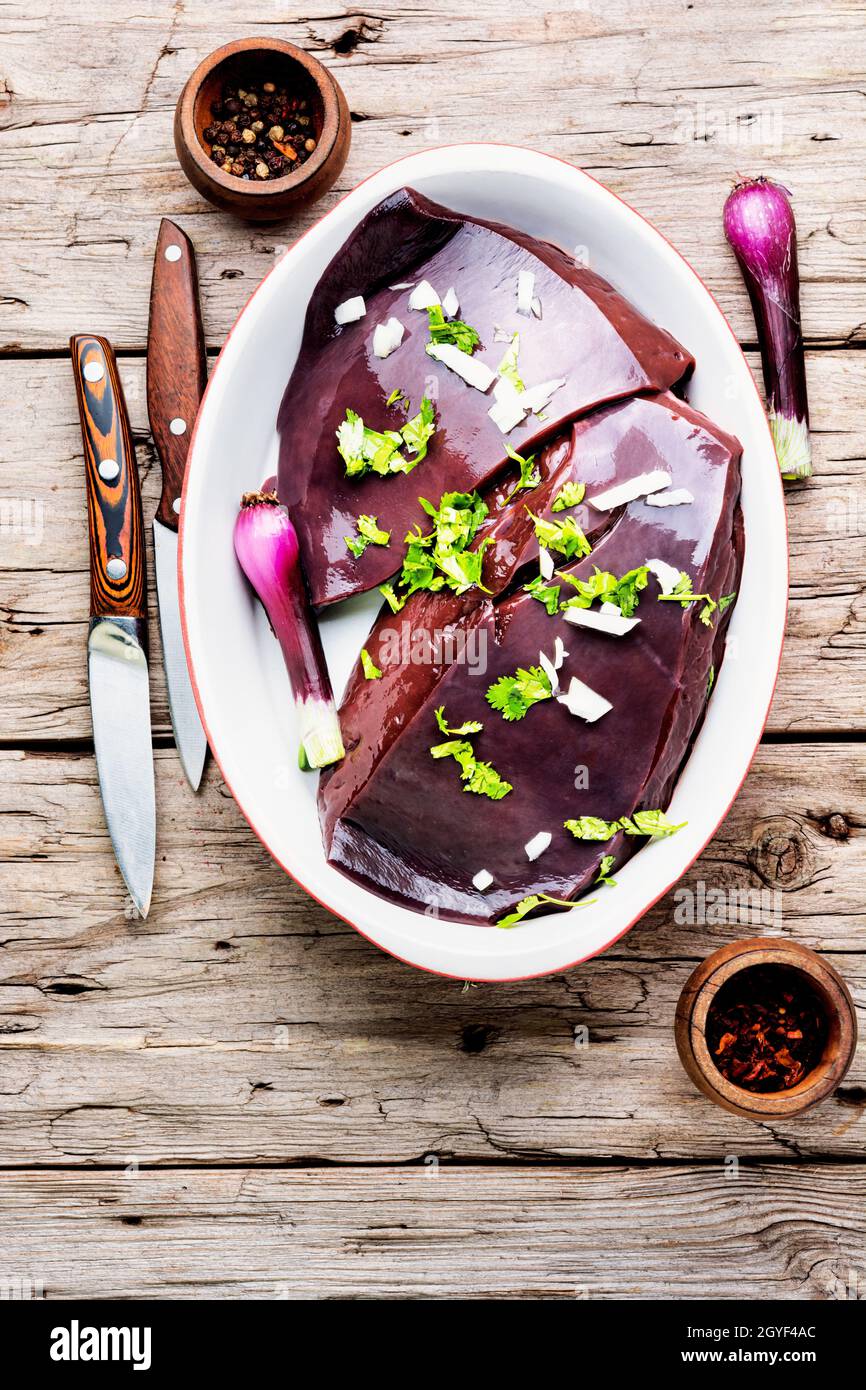 Piece of raw beef liver on the kitchen table.Fresh uncooked liver Stock ...