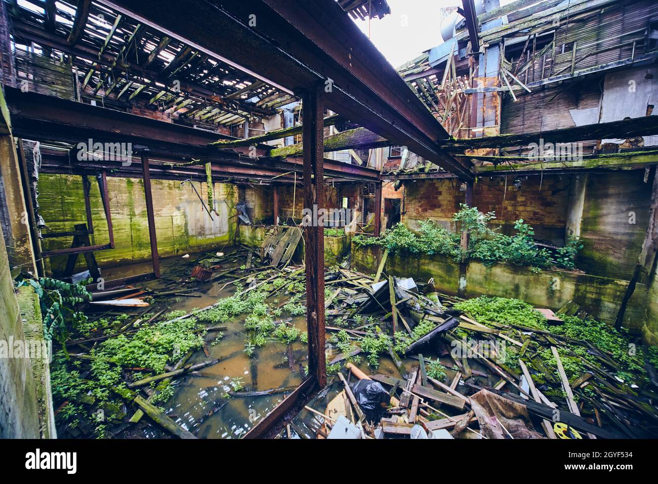 Inside large abandoned building with flooding and collapsed floors ...