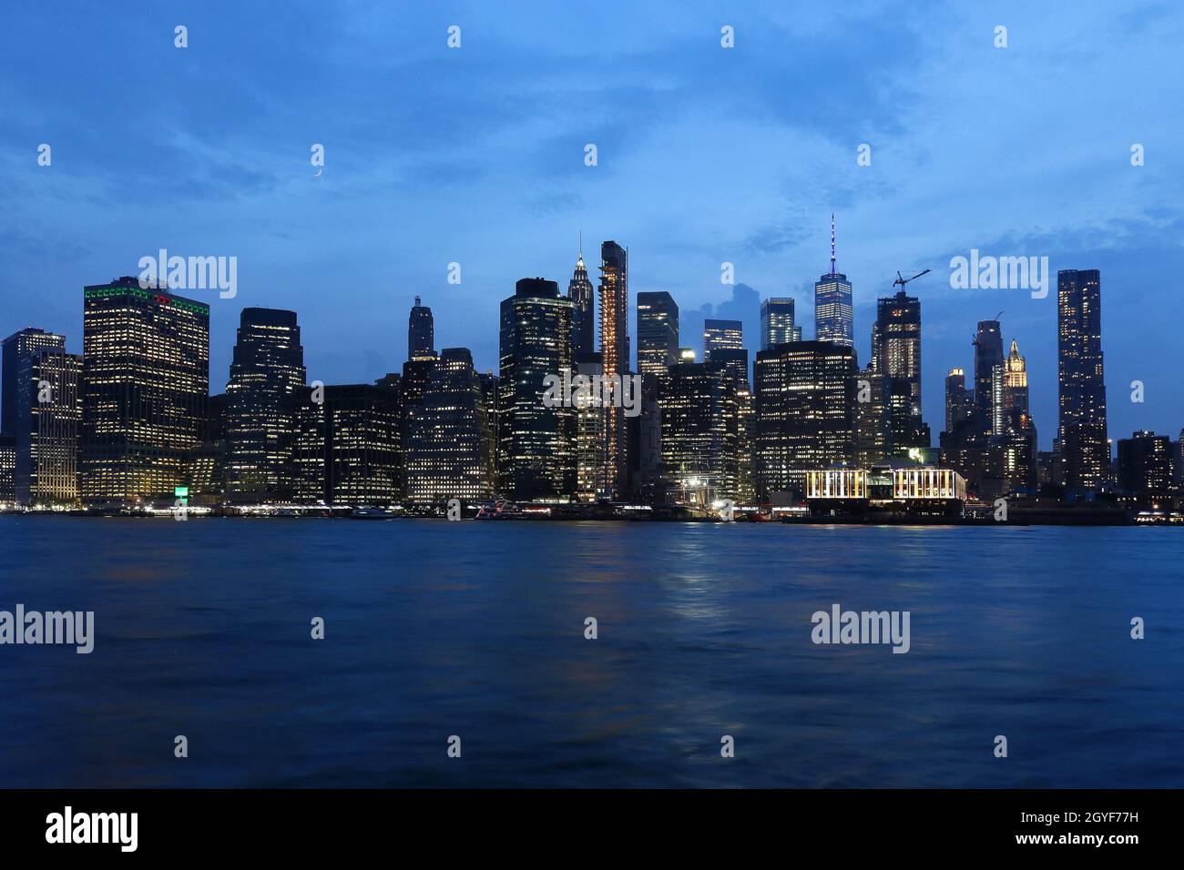 View of lower Manhattan skyline from East river coast during night ...