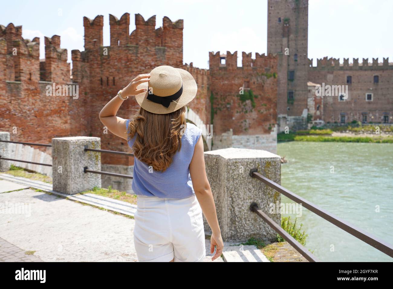 Promenade riverside in Verona, Italy. Back view of lady walking along ...