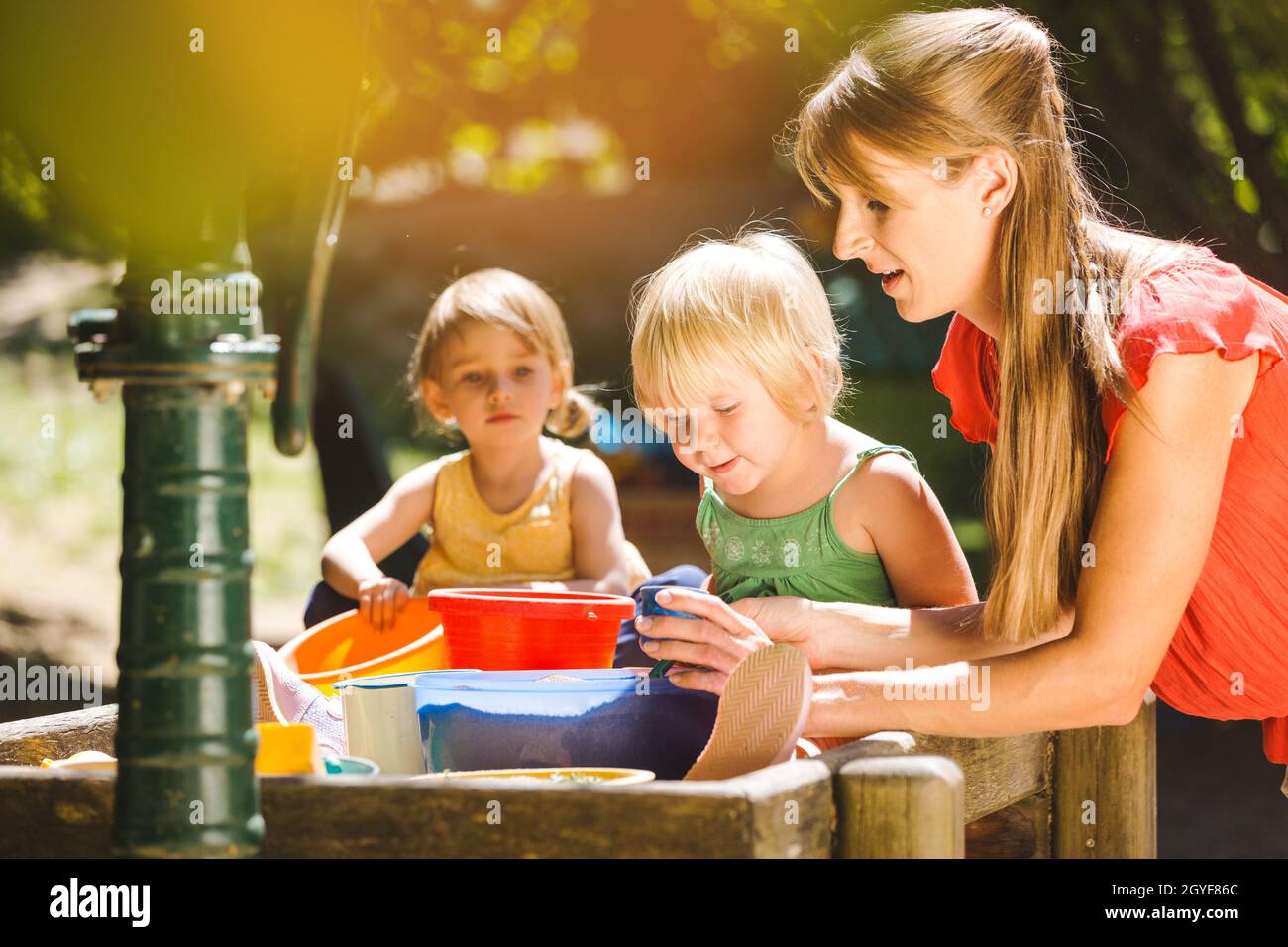 Kindergarten children and teacher playing together on playground Stock ...