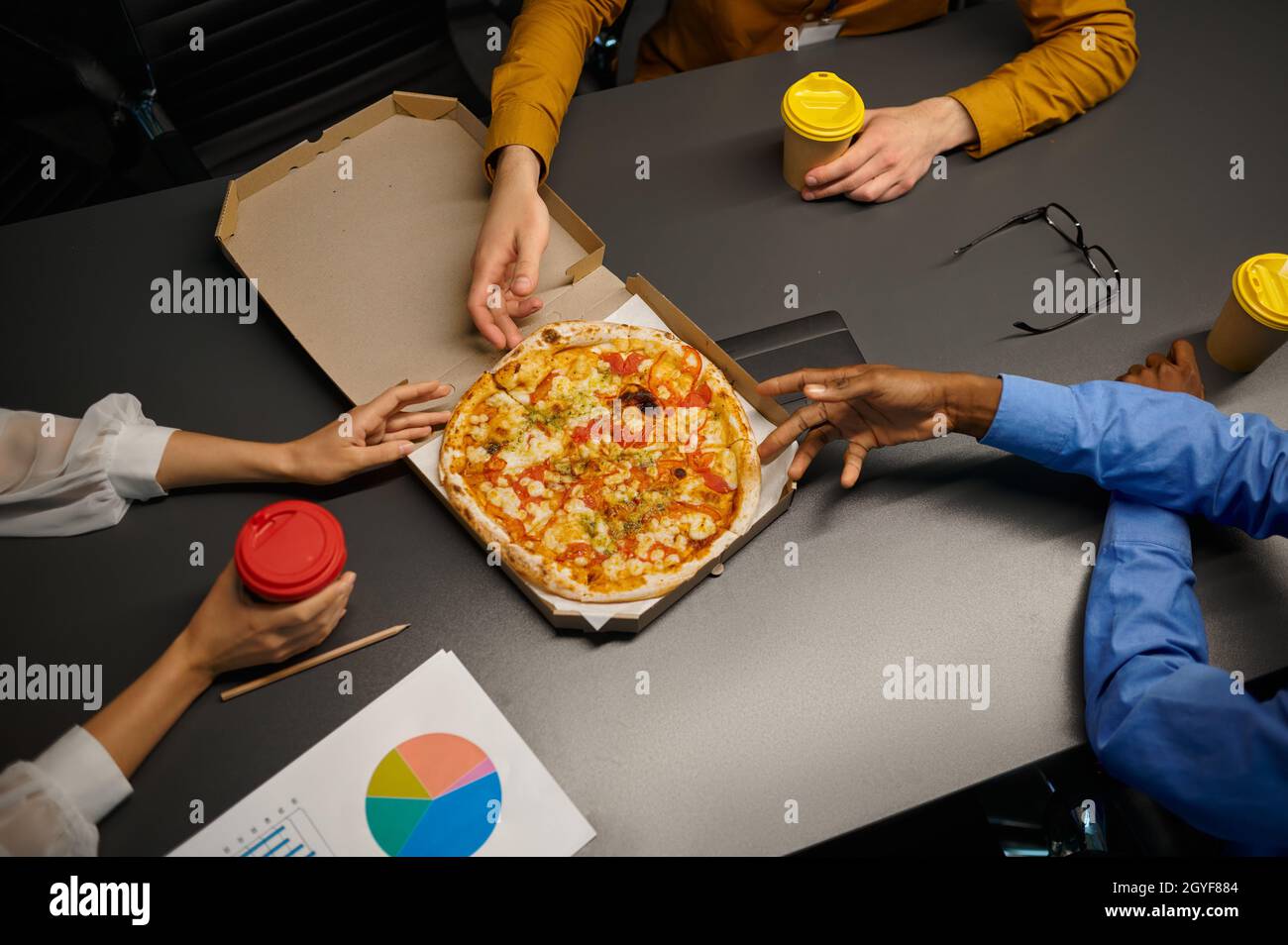 Team of managers eats pizza, business lunch in IT office. Professional ...