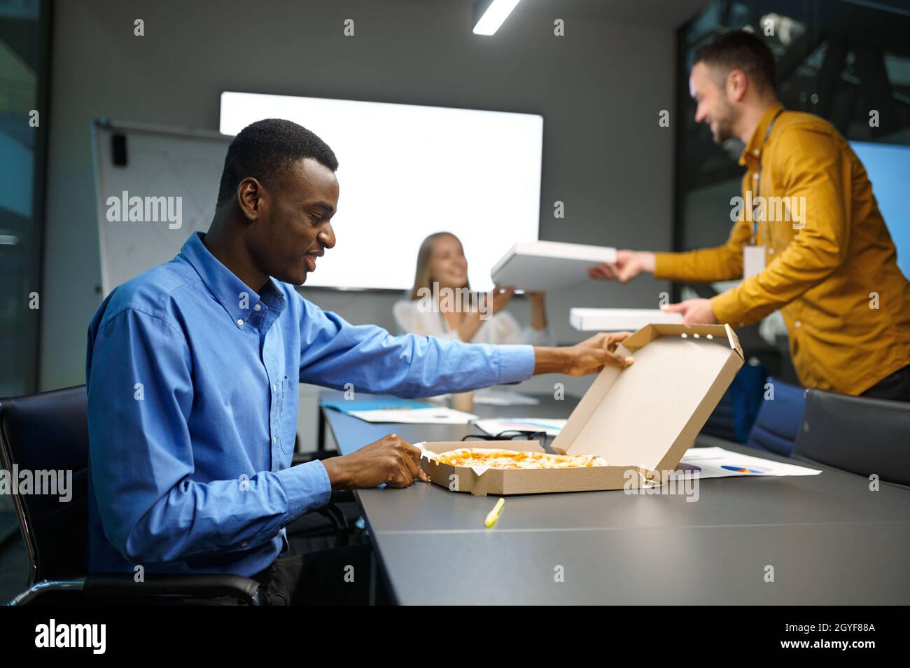 Team of workers eats pizza, business lunch in IT office. Professional ...