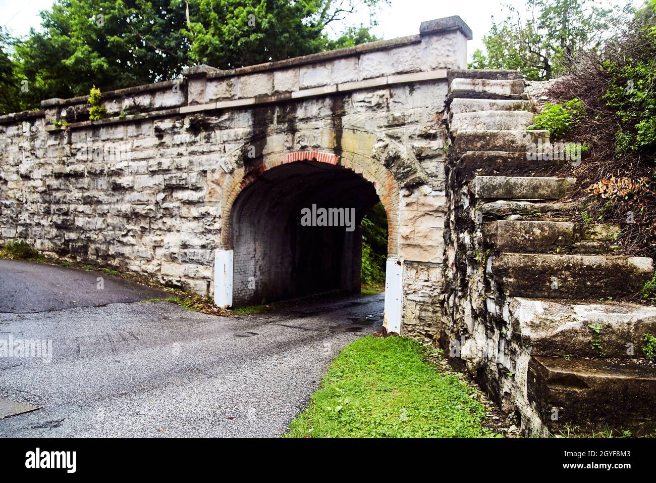 Small road going under stone tunnel with stone steps to the top Stock ...