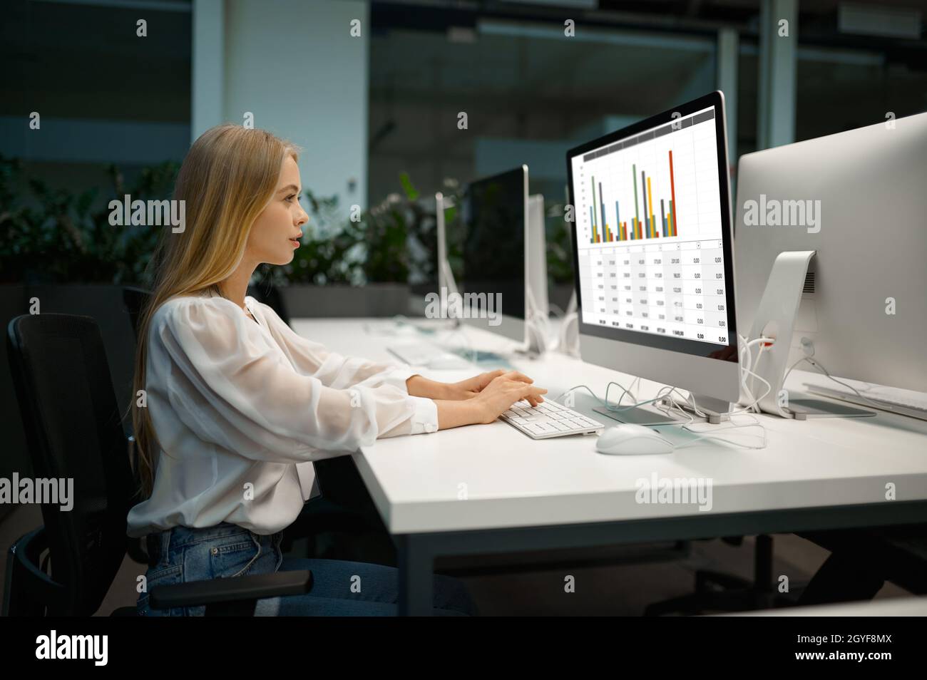 Female manager works on computer, IT office interior on background ...