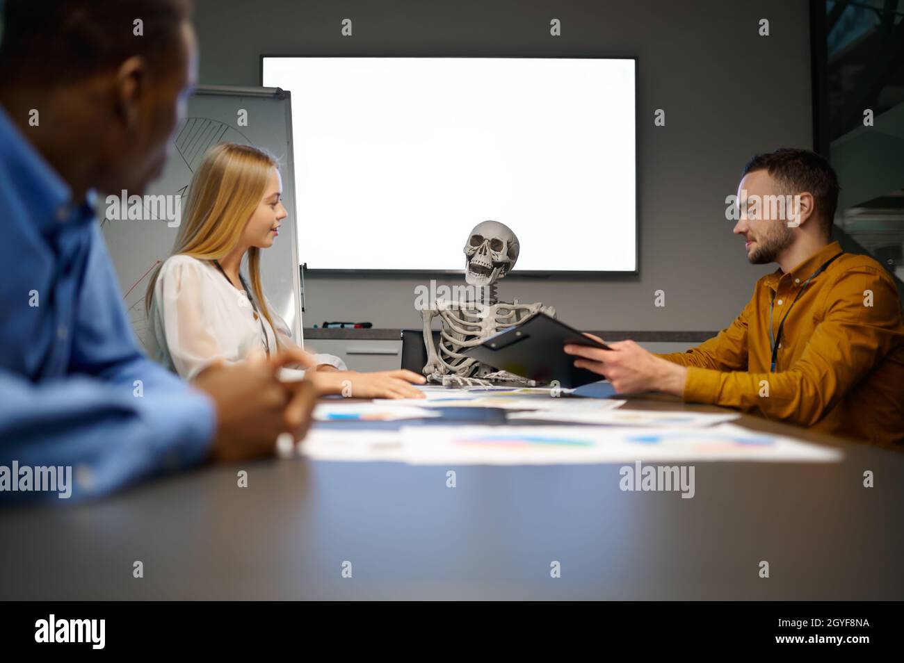 Team of managers and skeleton, conference in IT office, joke ...