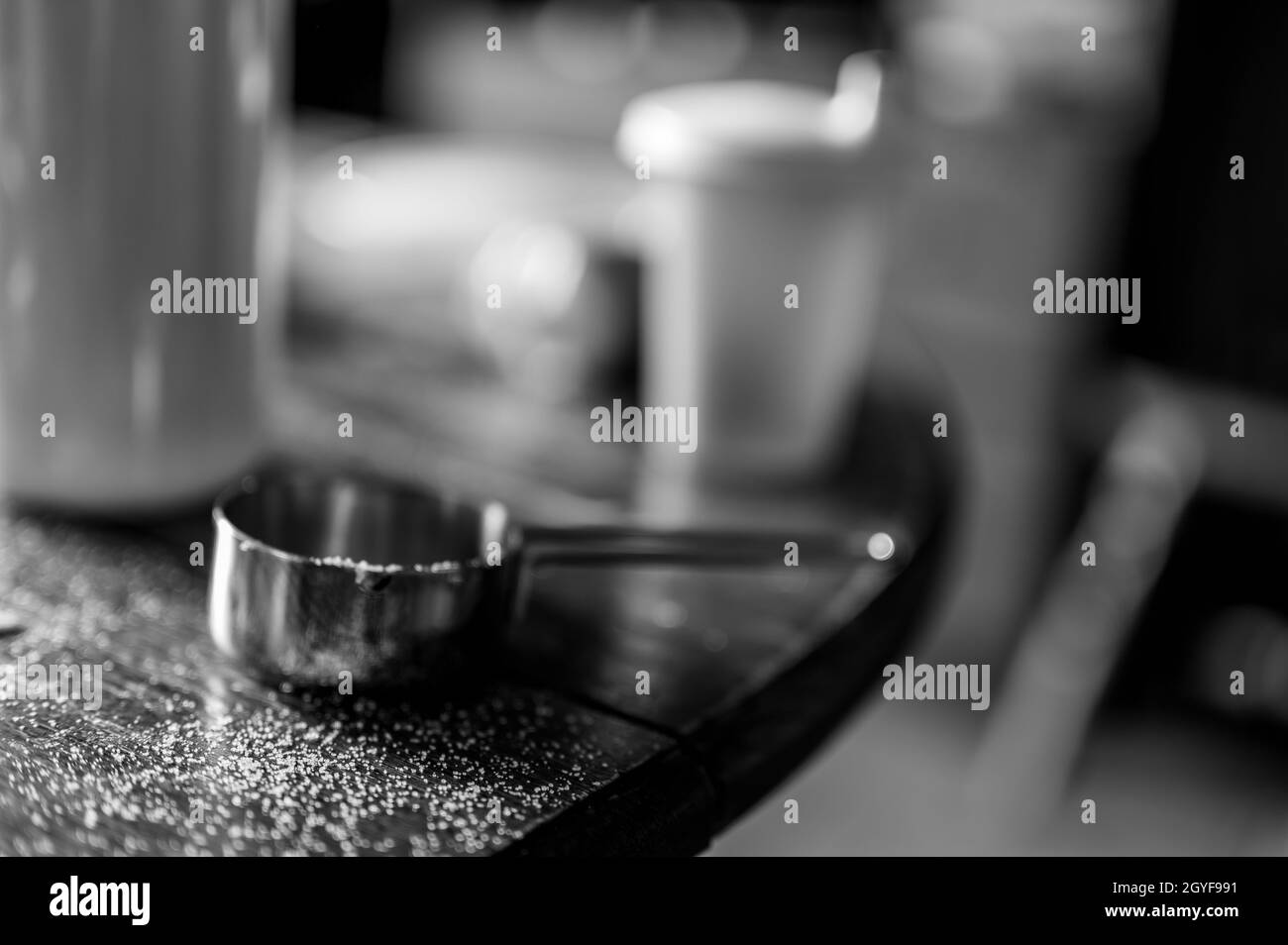 Messy kitchen table top with measuring cup and granules of sugar Stock ...