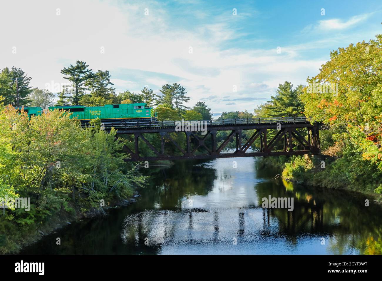 Eastern Maine Railroad crossing bridge over river on an early fall ...