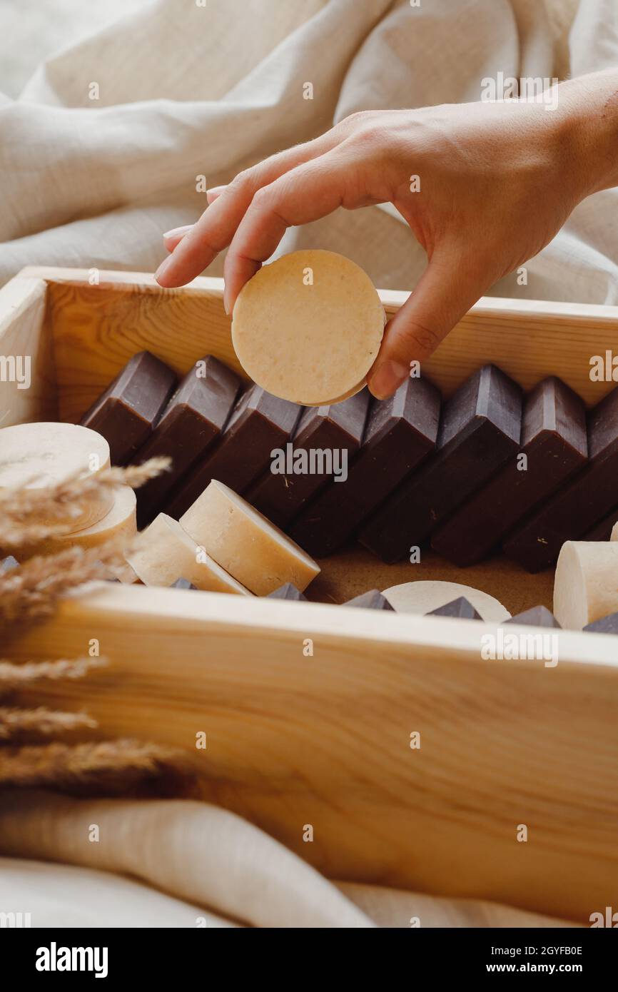 Hand take homemade soap from wooden box full of natural solid shmpoo ...