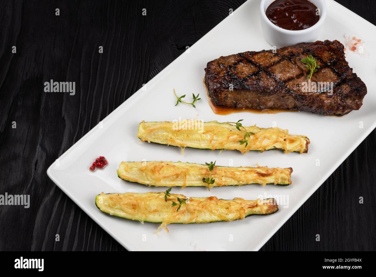 Grilled black angus strip loin steak New York with zucchini on white ...