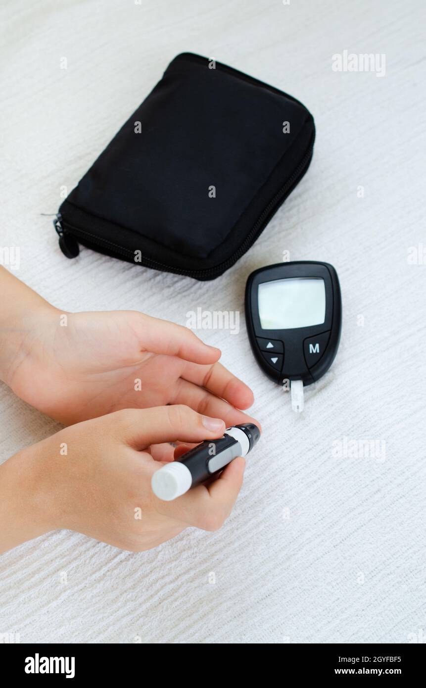 Child Hands Using Lancet on Finger to Check Blood Sugar Level by ...