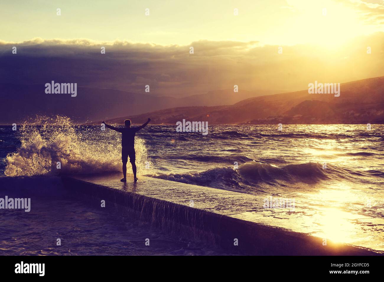 Feeling of freedom concept. Man standing on pier facing to the sea with ...