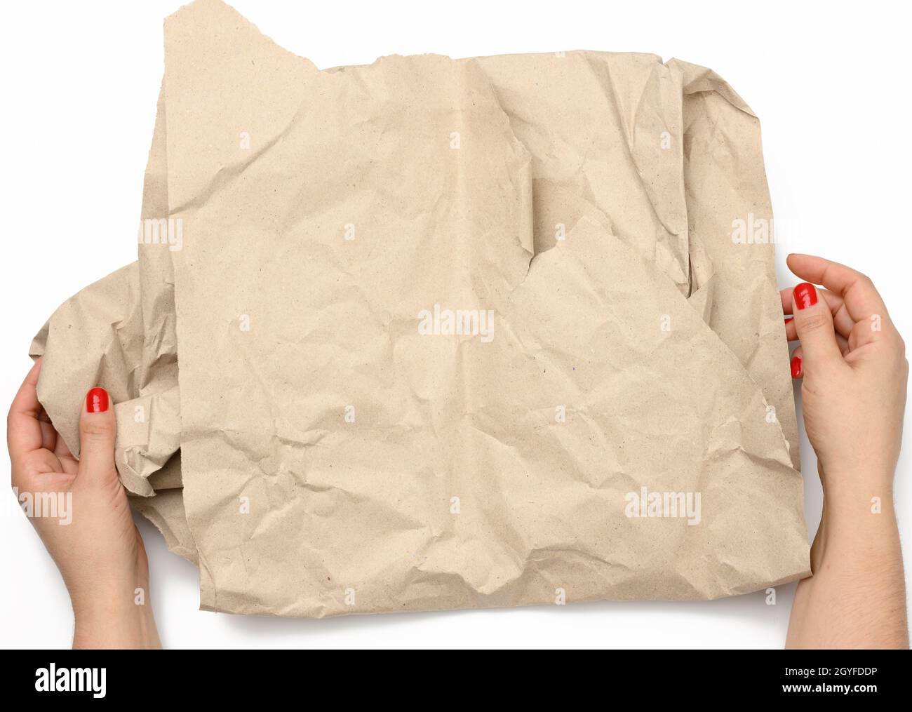 female hands hold crumpled brown paper on white background, top view ...
