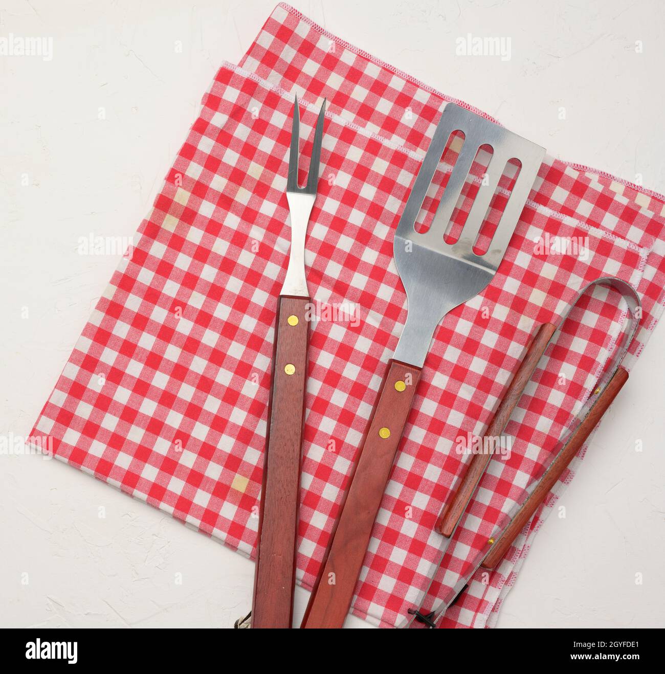 metal kitchen items with wooden handles for barbecue on white ...