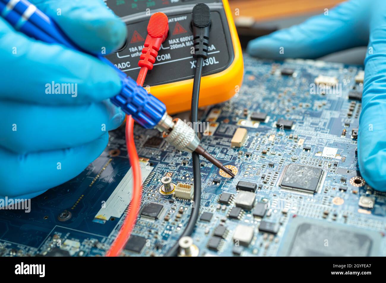technician repairing inside of hard disk by soldering iron. Integrated ...