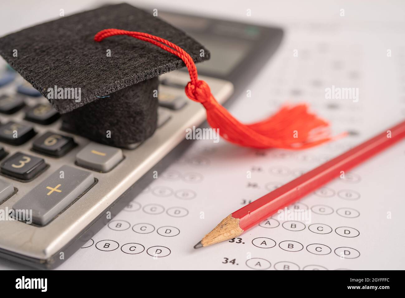 Graduation gap hat and pencil on answer sheet background : Education ...