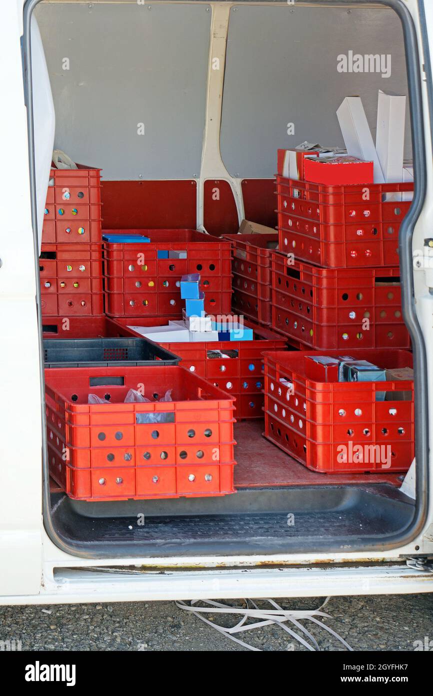 Open door of a van with goods inside plastic crates that need to be ...