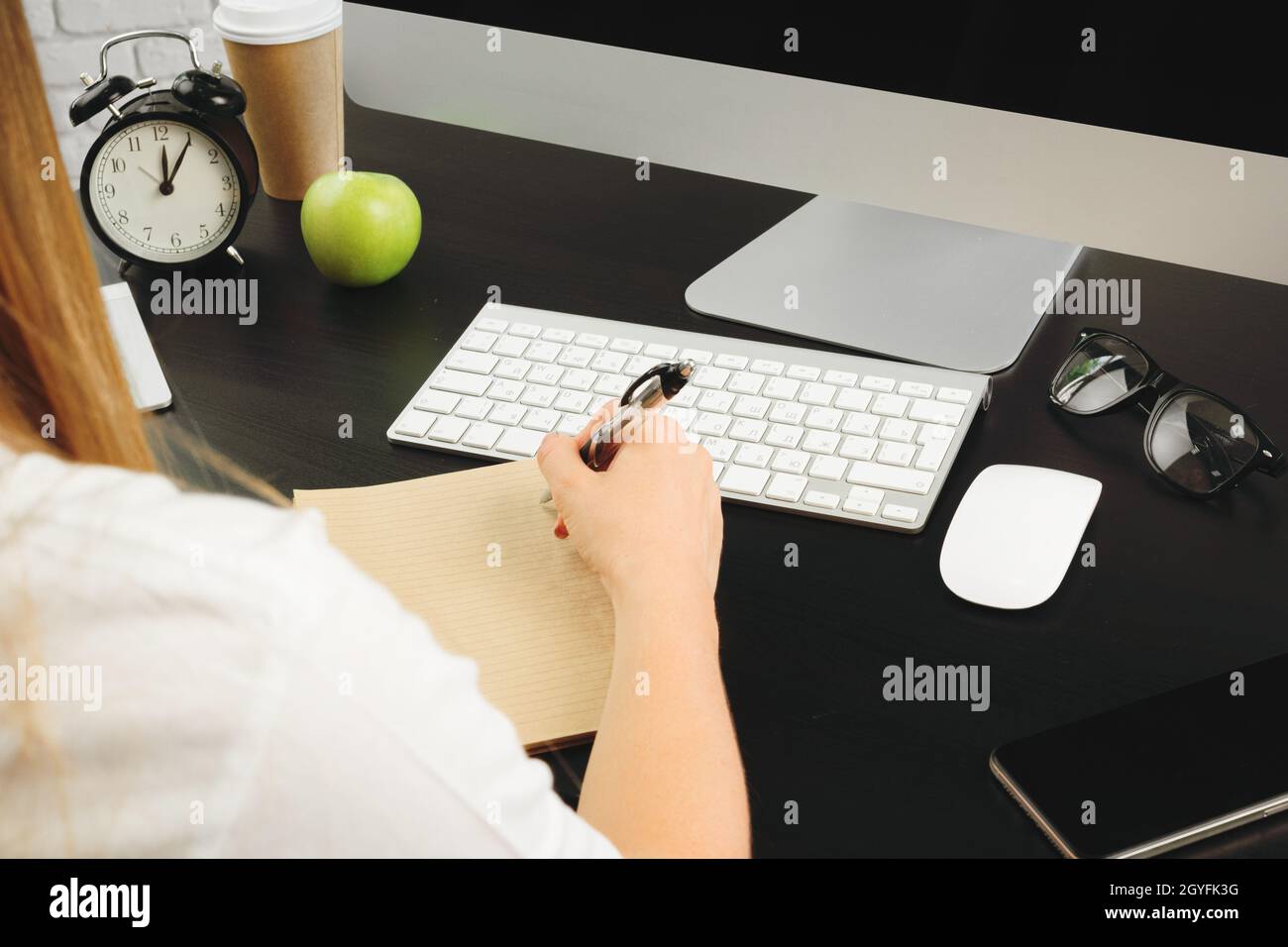 Woman making notes in notepad in an office Stock Photo - Alamy
