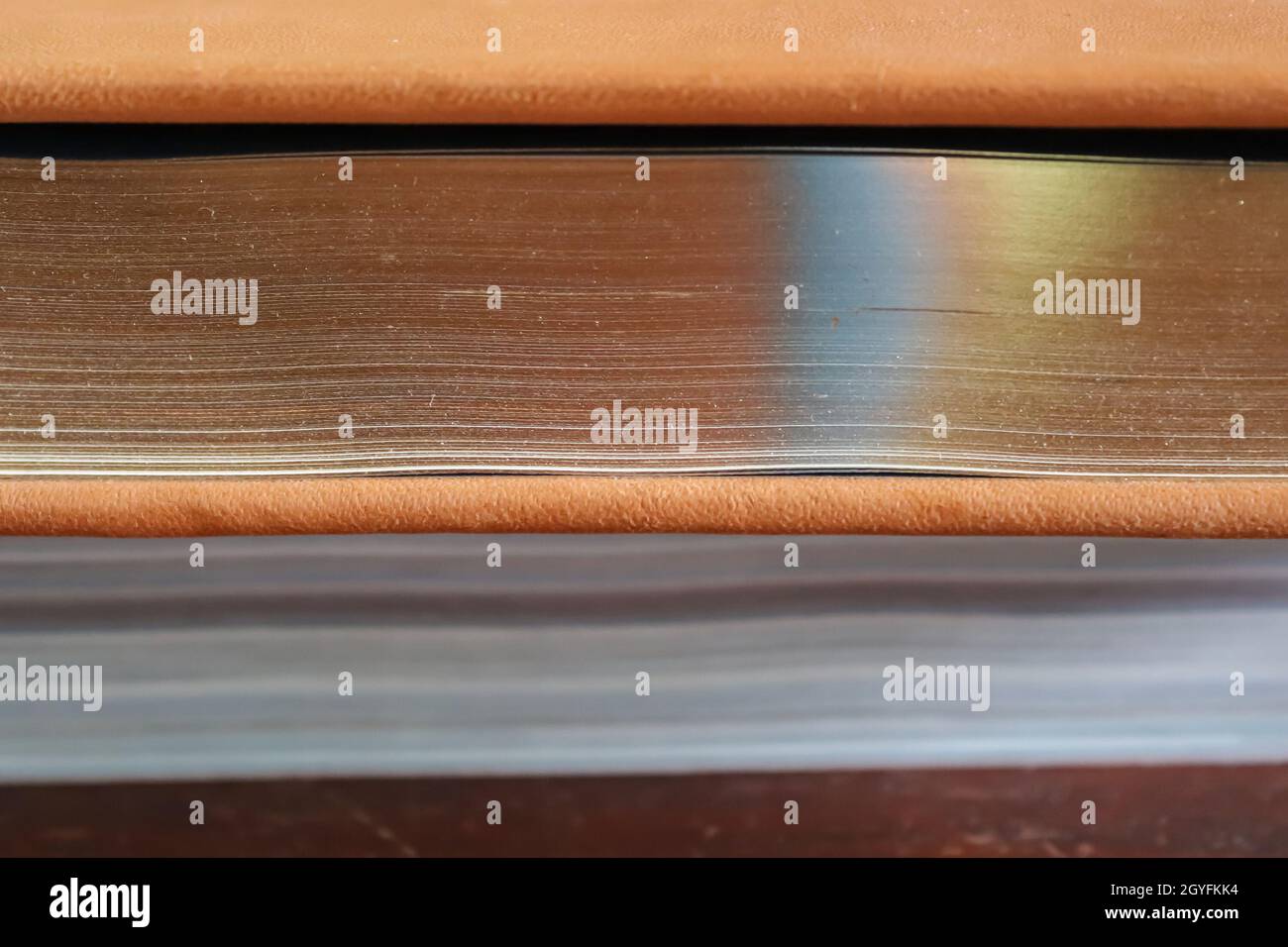 Close up view at a thick old book with golden pages. Side view Stock ...