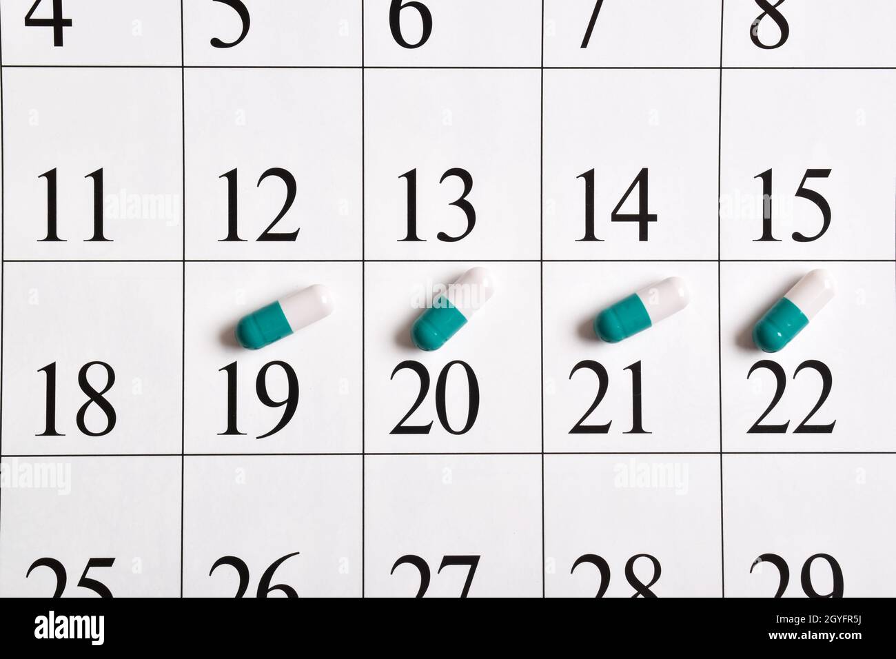 Medicines. A close-up of green capsules with pills is in the calendar ...
