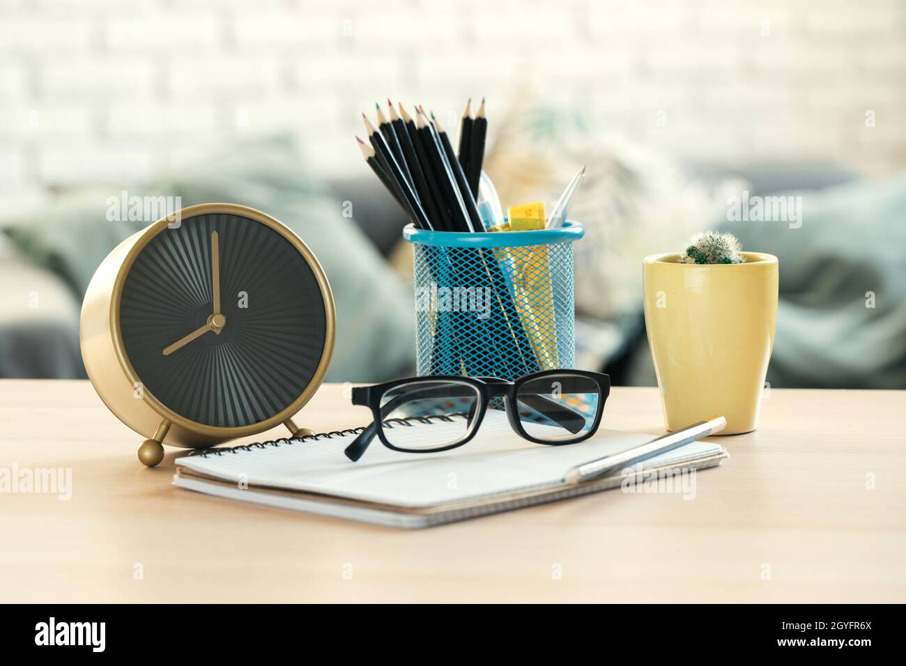 Alarm clock and office stationery objects close up on wooden table ...