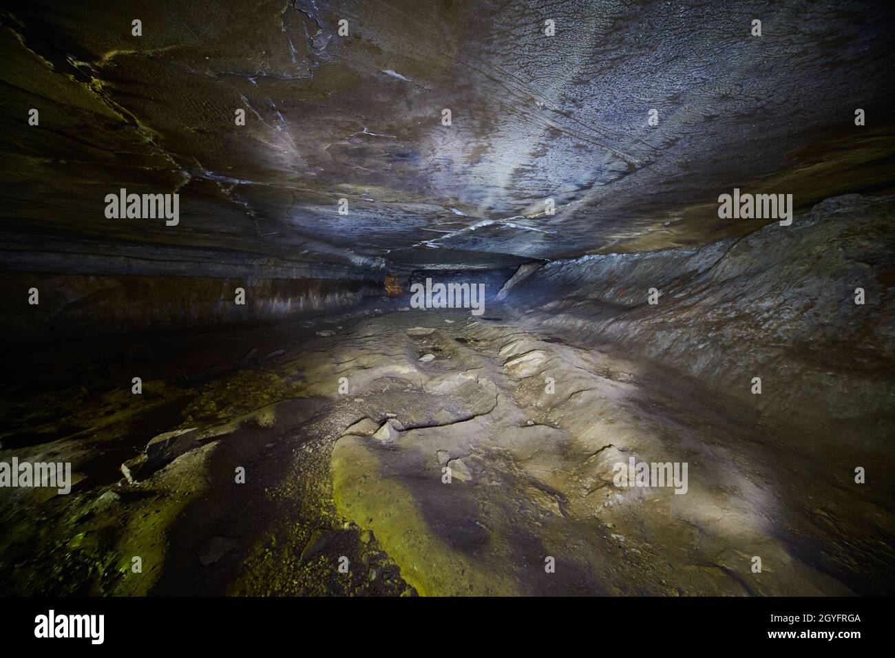 Wide cave that is short and has a smooth ceiling but a bumpy floor ...
