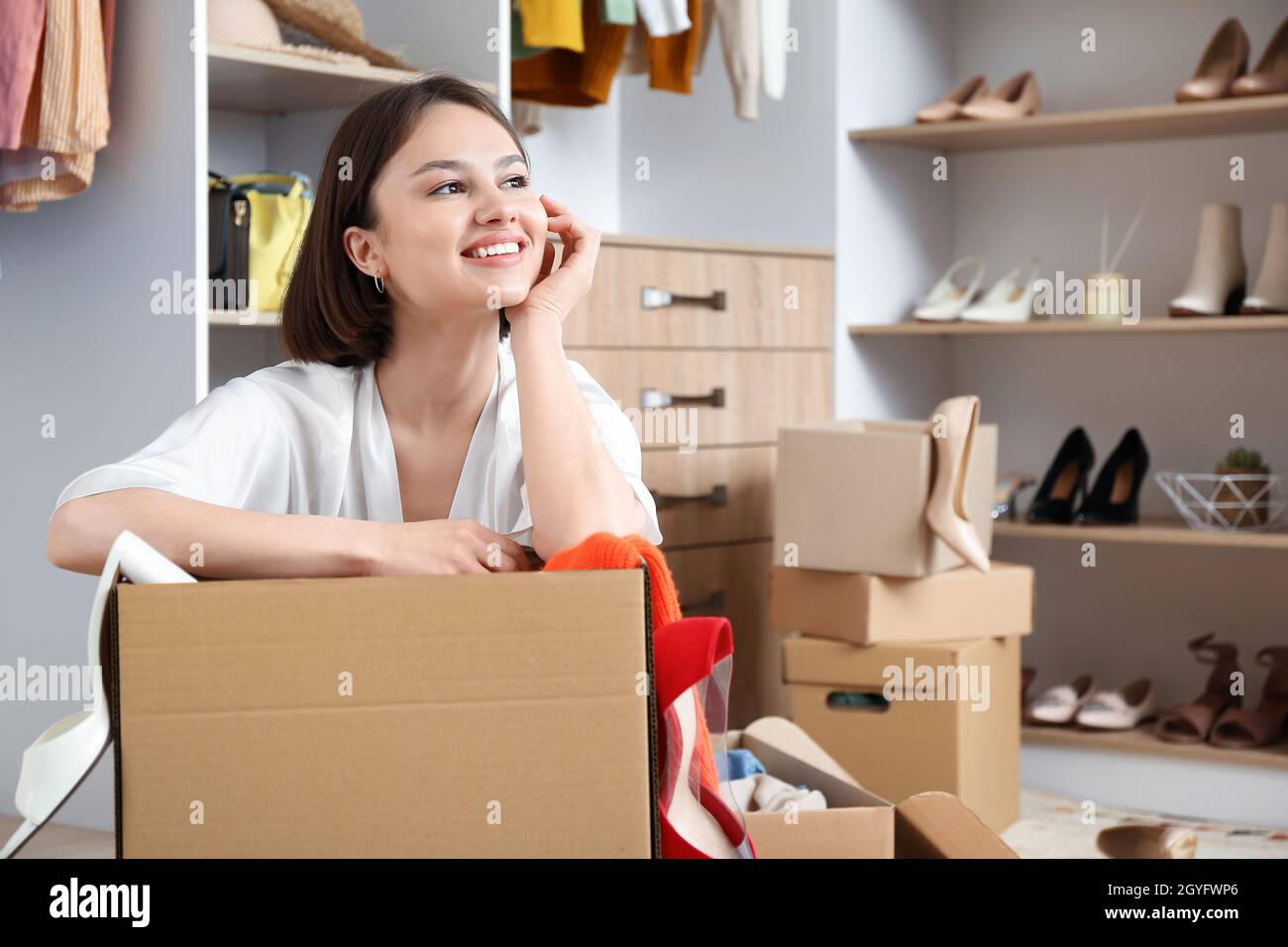 Young woman with wardrobe box and clothes in dressing room Stock Photo ...
