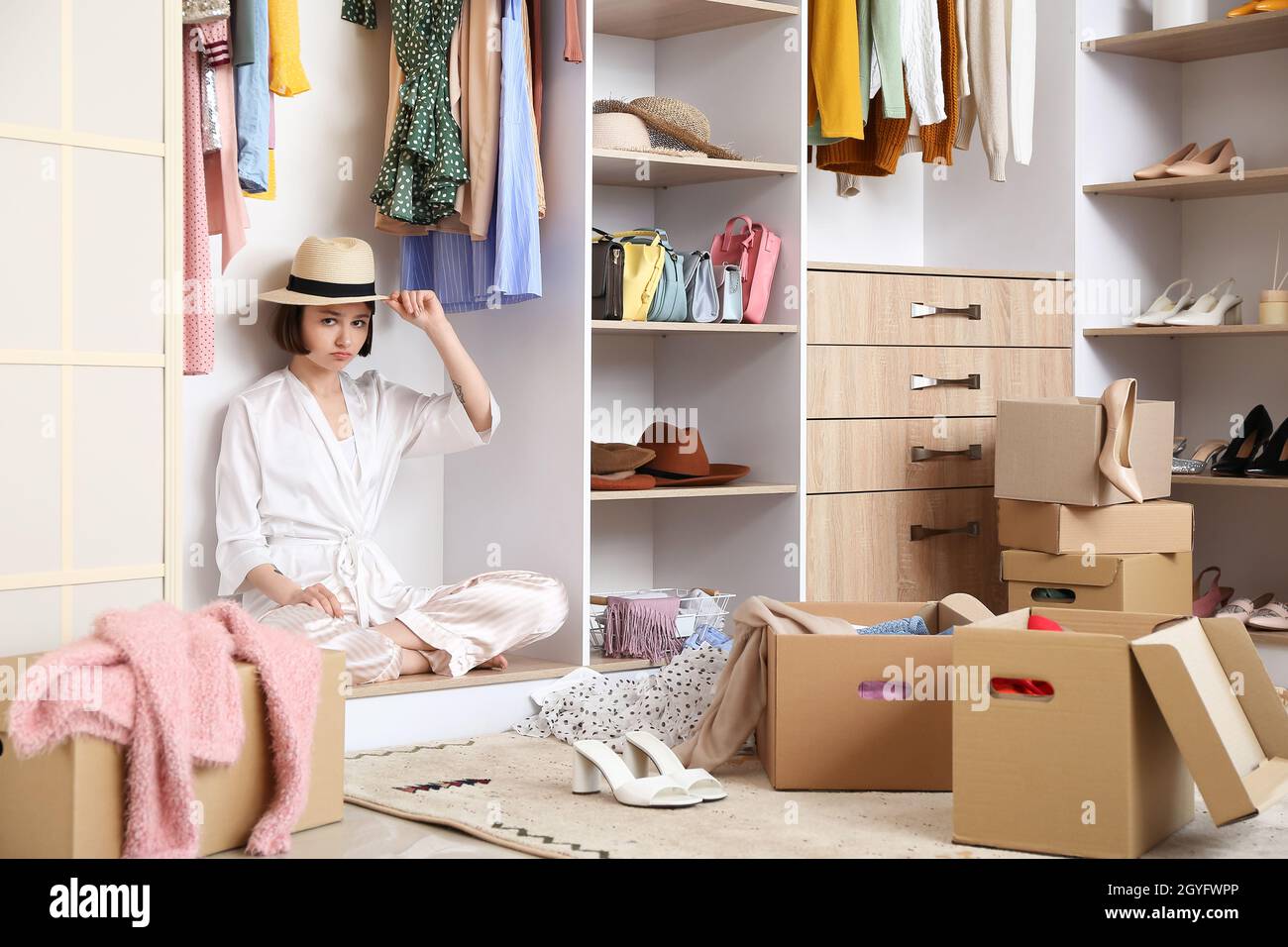 Young woman arranging clothes at wardrobe Stock Photo - Alamy