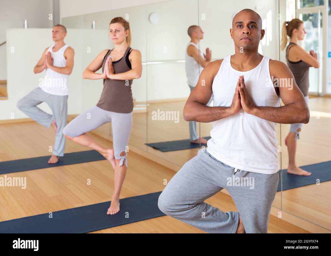 Latin american man standing in balancing pose Eka Pada Pranamasana ...
