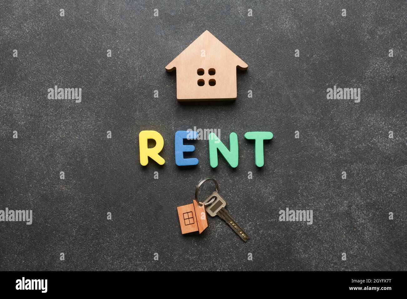 Wooden house with word RENT and key on black background Stock Photo - Alamy
