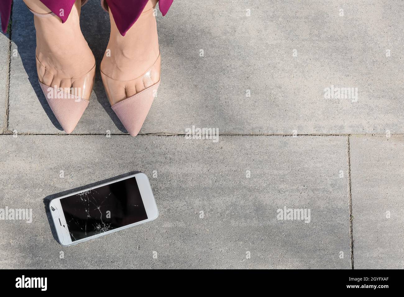 Legs of woman in heels and damaged mobile phone on pavement outdoors ...