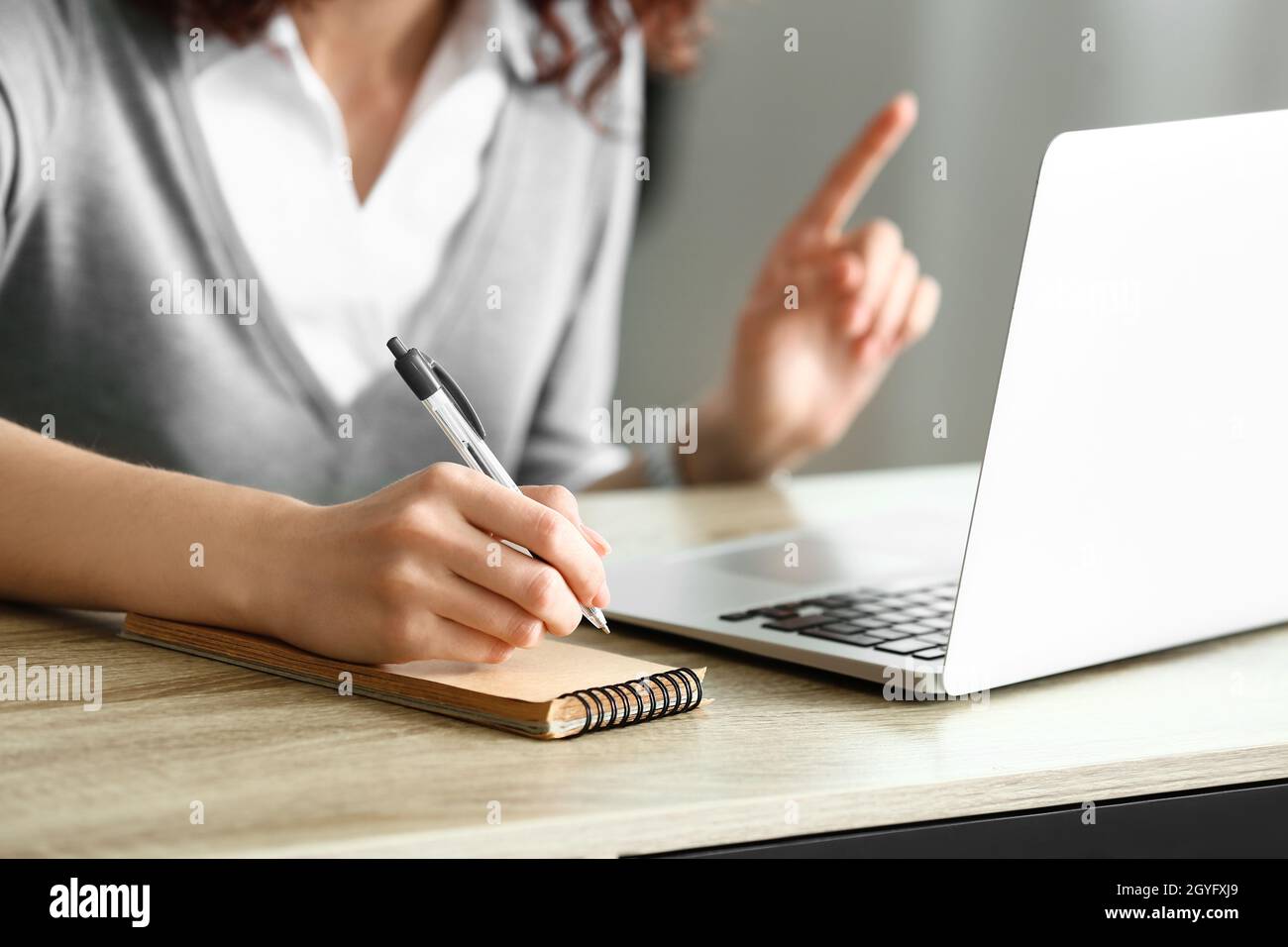 Young woman writing notes during online job interview at home Stock ...