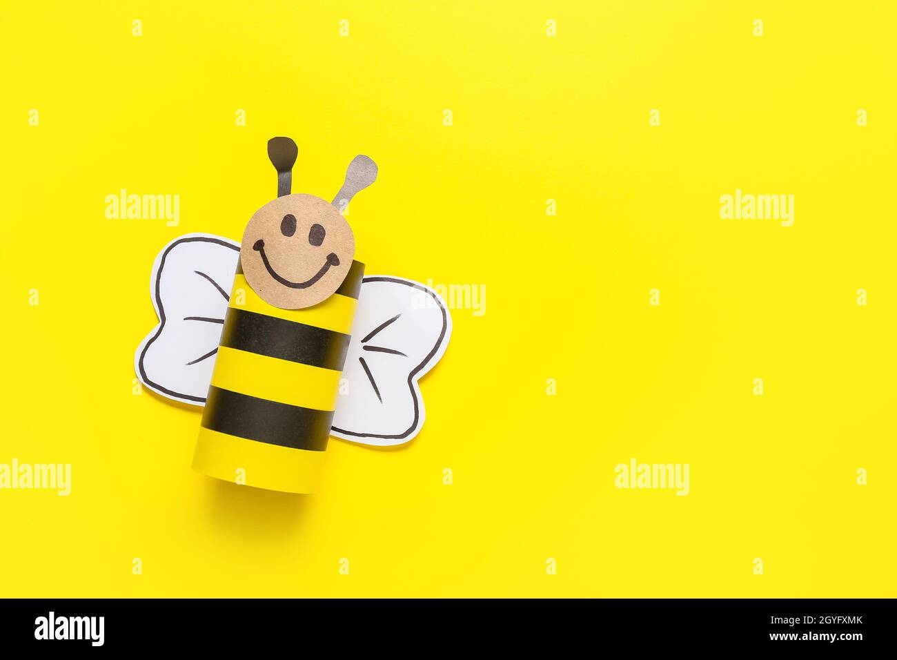 Figure of bee made of cardboard tube for toilet paper on yellow ...