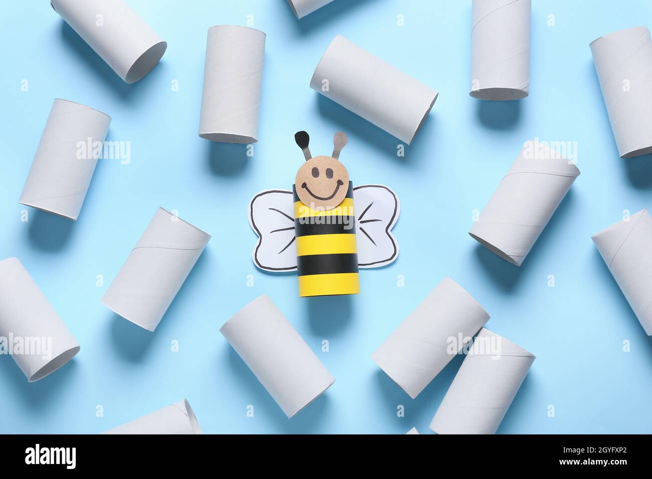 Bee made of cardboard and tubes for toilet paper on blue background ...