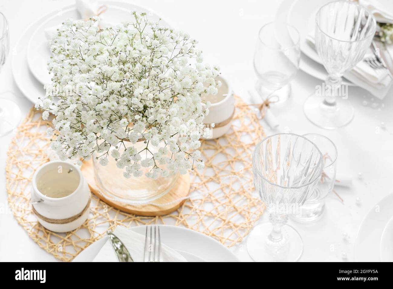 Beautiful table setting with gypsophila flowers on light background ...