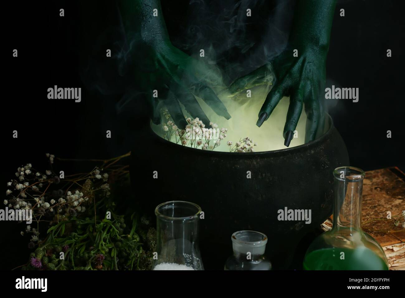 Evil witch making potion in cauldron Stock Photo - Alamy