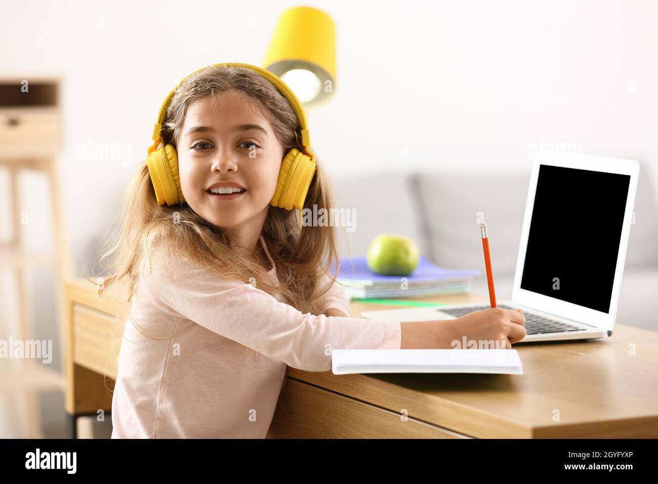 Little girl doing lessons online at home Stock Photo - Alamy